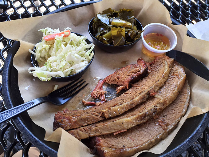 Brisket so tender it practically surrenders to your fork, flanked by crisp coleslaw and collards that mean business.