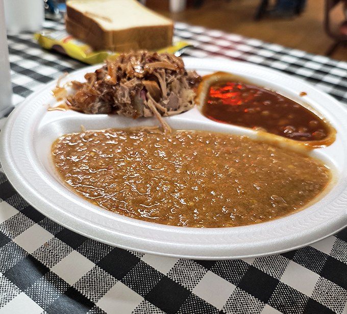 The legendary Brunswick stew, thick enough to stand a spoon in, sits alongside pulled pork like royalty on a humble paper plate.