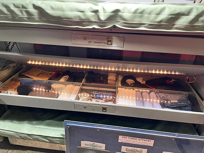 Red lighting bathes the sleeping quarters, preserving night vision for sailors on watch while creating an otherworldly submarine ambiance.