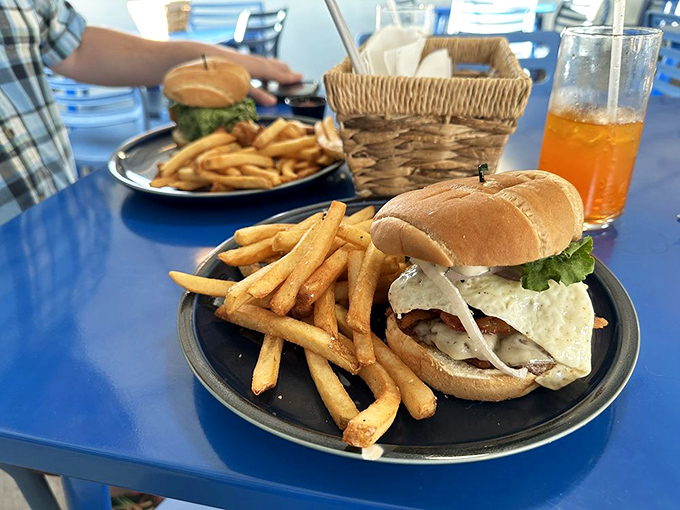 This isn't just a burger; it's edible architecture. Golden fries stand at attention beside a sandwich that demands both hands and your full attention.