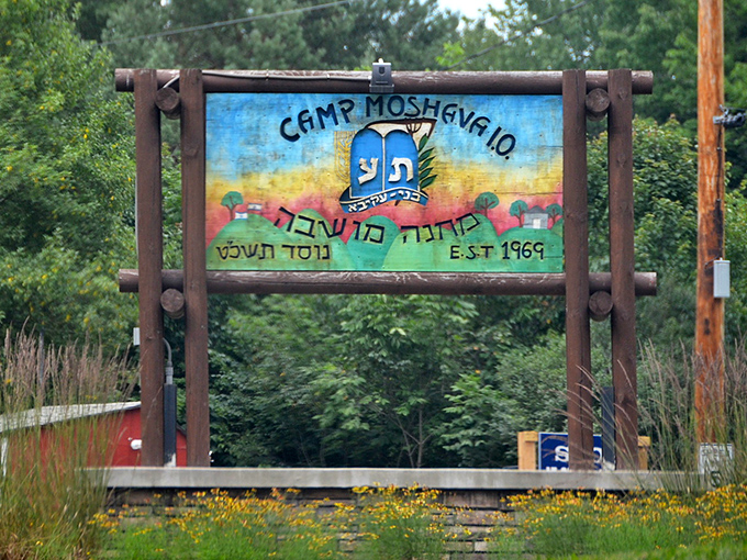 Camp Moshava's colorful welcome sign stands as a cheerful gateway to summer memories, where kids trade screen time for sunshine.