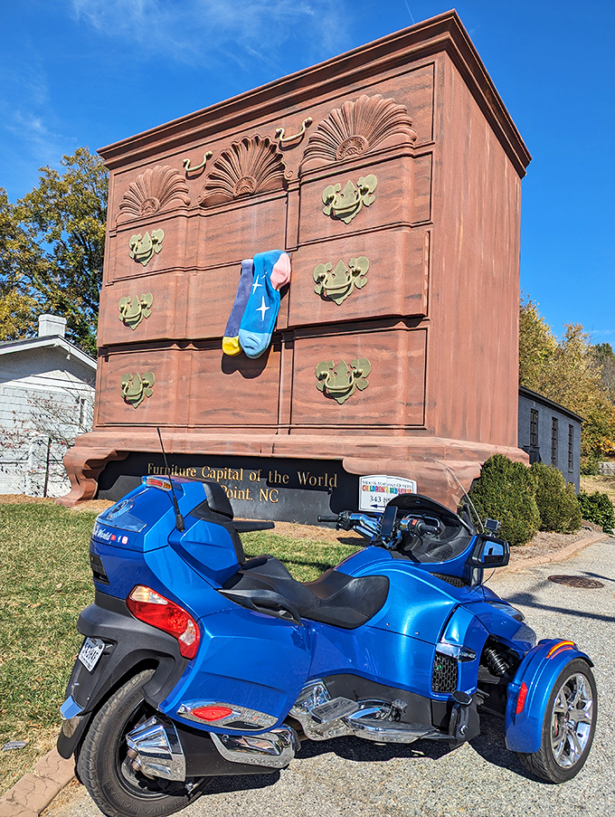 A blue Can-Am Spyder poses with its wooden counterpart, both masterpieces of design that make onlookers stop and stare.