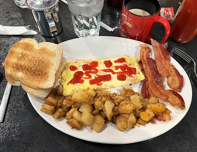 Breakfast nirvana: fluffy eggs adorned with just the right amount of hot sauce, perfectly crisped bacon, and home fries that demand attention.