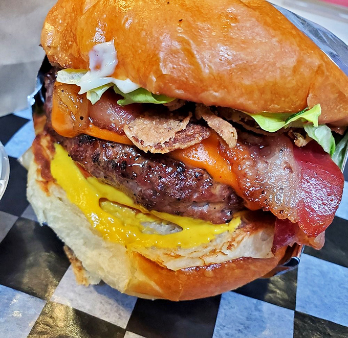 This isn't just a burger—it's architecture, art, and pure joy stacked between a golden bun. The melty cheese cascades like a yellow waterfall of happiness.