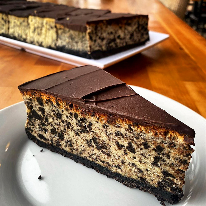 This isn't just cheesecake—it's architecture with a chocolate roof. The kind of dessert that makes conversation stop mid-sentence when it arrives.