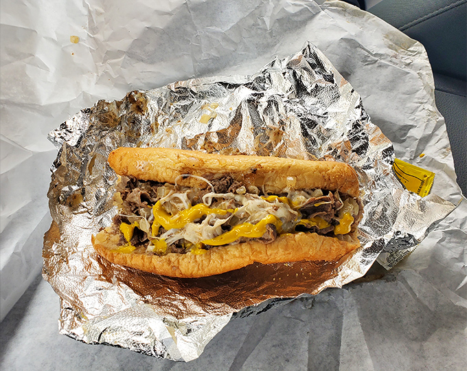 Behold the star of the show in all its messy glory. Thinly sliced beef, melted cheese, and those perfectly caramelized onions create sandwich perfection.