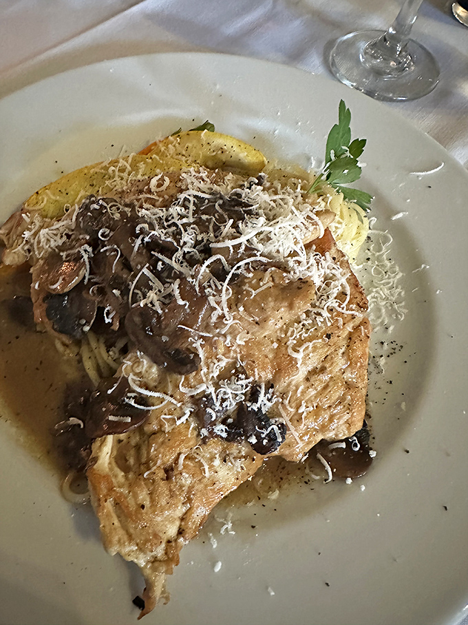 Chicken and mushrooms performing a delicious tango atop pasta. The shaved parmesan snowfall on top isn't just garnish&mdash;it's essential happiness.