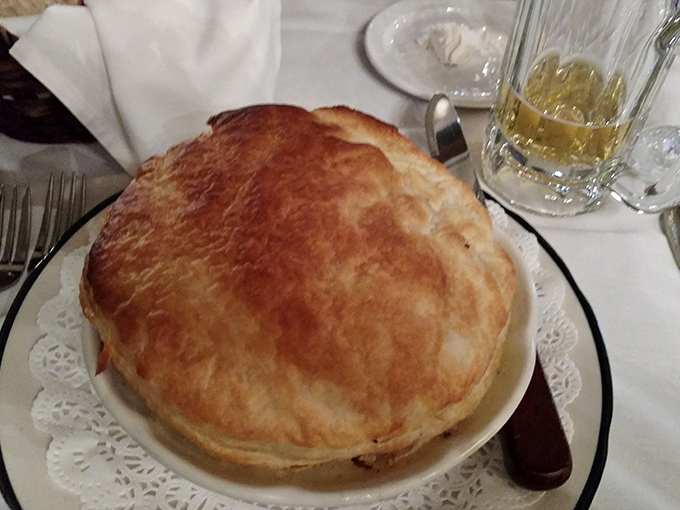 The chicken pot pie arrives like a golden-domed cathedral of comfort. Breaking through that flaky crust releases steam that smells like your grandmother's kitchen&mdash;if grandma was a classically trained chef.