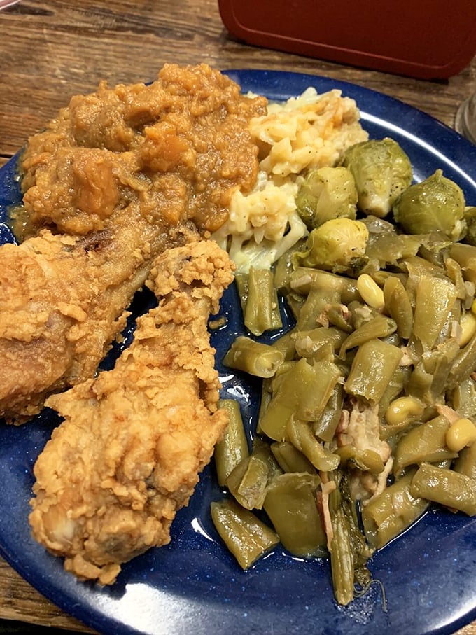 Golden-crisp fried chicken alongside country green beans and mac and cheese – this isn't just a plate, it's Southern heritage on blue dishware.