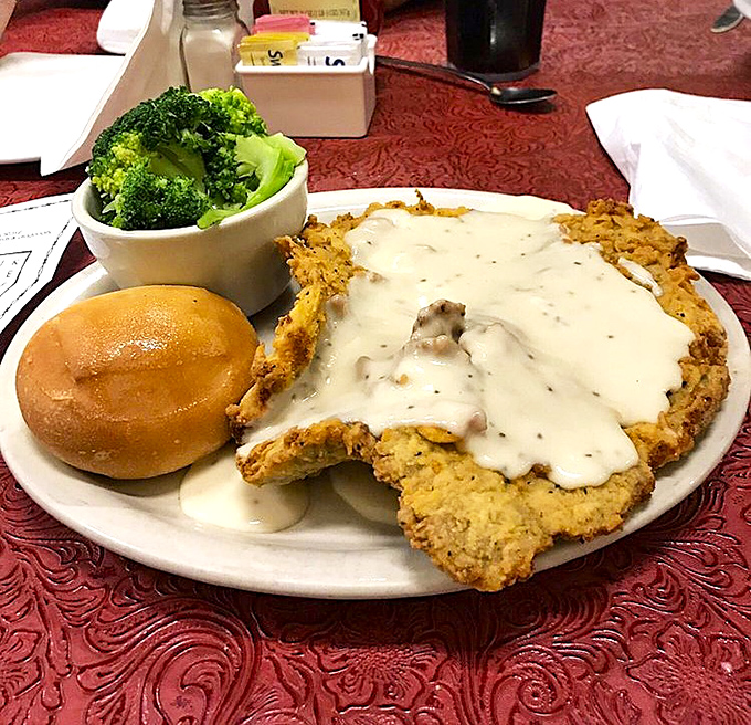 Behold the crown jewel of Texas cuisine! This chicken fried steak doesn't just hang over the plate's edge &ndash; it demands respect and extra napkins.