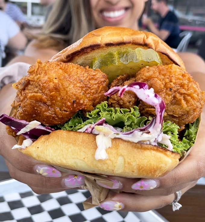 This isn't just a sandwich; it's an architectural masterpiece of crispy chicken, house pickles, and slaw that requires both hands and zero shame.