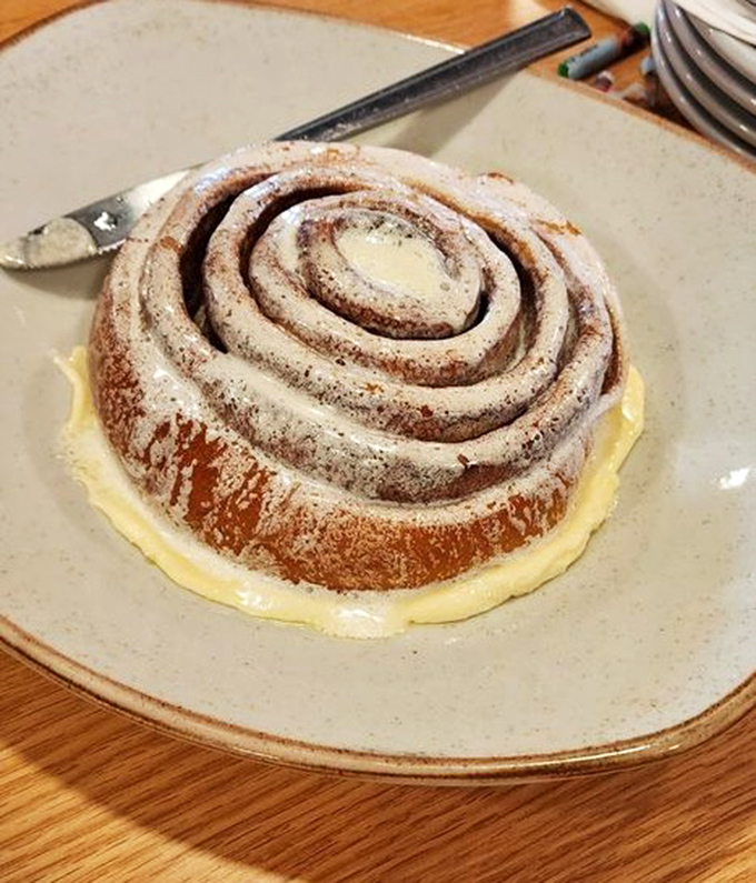 The legendary cinnamon roll arrives like a spiral-bound promise of sweetness, demanding both hands and zero guilt.