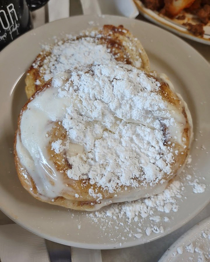 Behold the legendary Giant Grilled Cinnamon Roll! Caramelized edges, melting cream cheese, and a dusting of powdered sugar create breakfast nirvana.