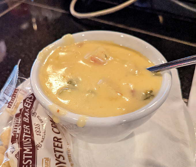 The legendary clam chowder arrives like a creamy golden promise in a bowl, with tender morsels waiting to be discovered beneath the surface.