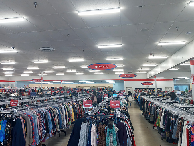 Color-coded clothing racks create a textile rainbow that would make Marie Kondo weep with organizational joy. Every hanger holds potential magic.