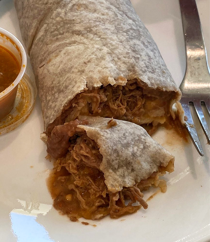 Behold the star attraction: a burrito bathed in that legendary sauce, melted cheese cascading down the sides like a delicious waterfall.