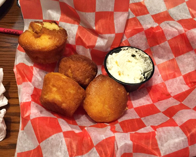 Golden-brown cornbread muffins that could make your grandma jealous, served with a side of butter that melts faster than your willpower. 