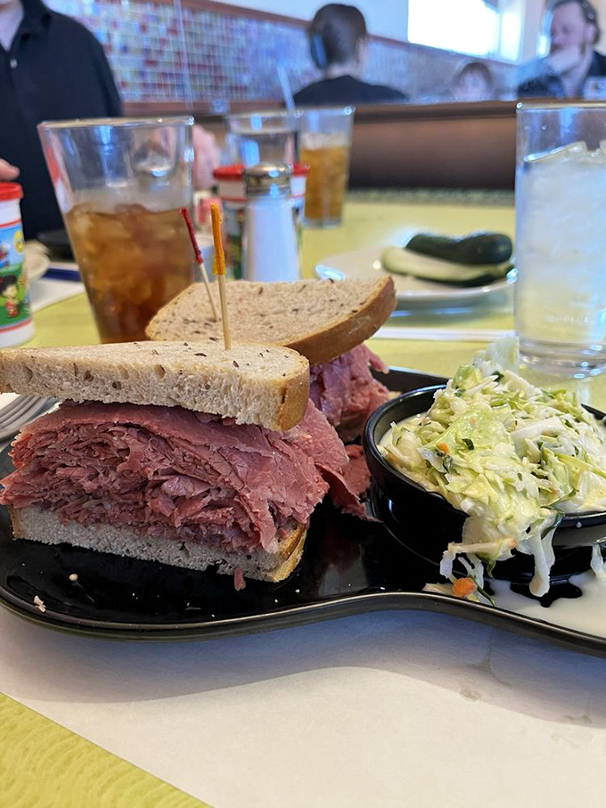 This isn't just a sandwich; it's a skyscraper of perfectly pink corned beef with a foundation of rye bread that somehow defies structural engineering.