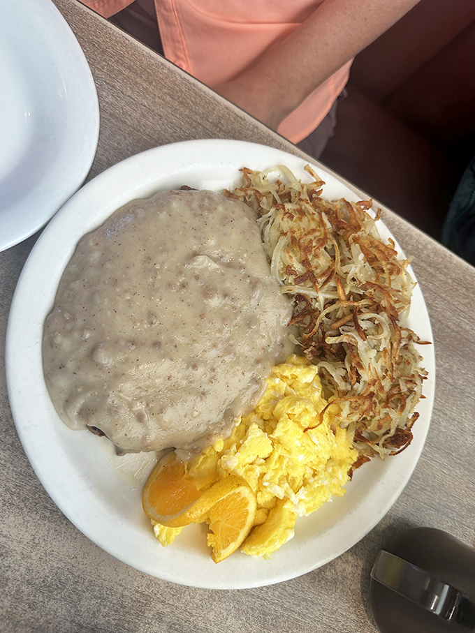 Comfort food perfection: creamy country gravy cascading over eggs and hash browns. The breakfast equivalent of a warm hug from your favorite aunt.