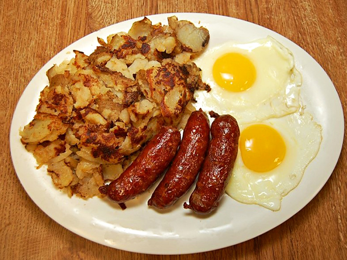 Breakfast nirvana achieved: golden home fries with that perfect crisp-tender balance, sausages with just the right snap, and sunny-side up eggs that practically high-five your taste buds.