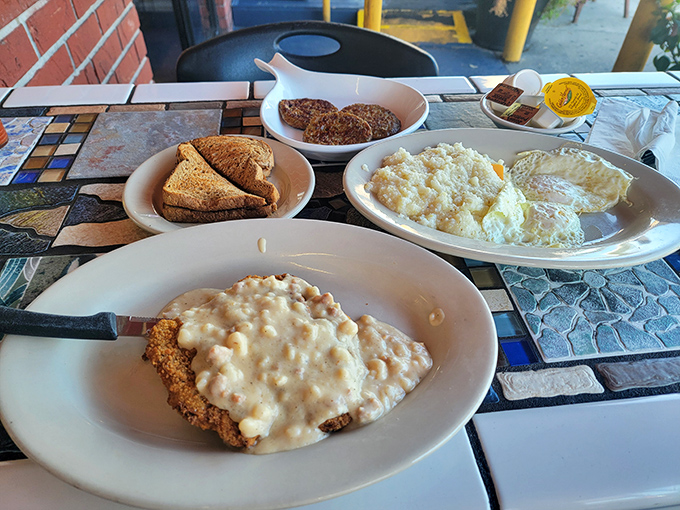Country fried steak smothered in peppery gravy alongside sunny-side-up eggs and grits &ndash; the breakfast equivalent of a warm hug from your favorite aunt.