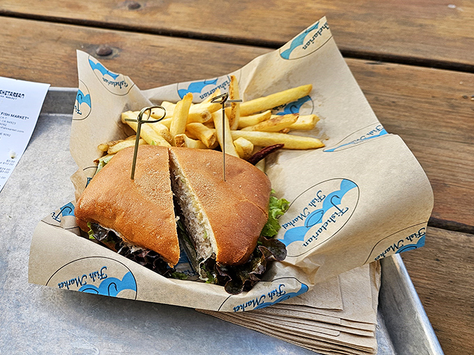 This sandwich isn't just lunch; it's edible architecture&mdash;layers of fresh seafood nestled between golden bread, with fries standing by for the supporting role.