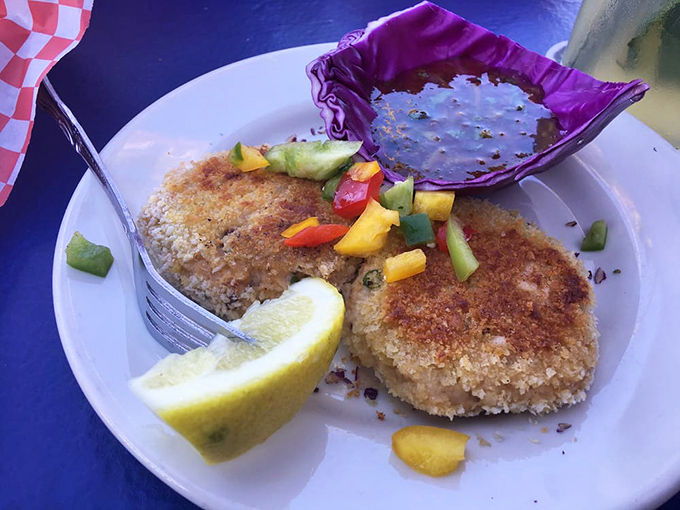 Golden-brown crab cakes with a colorful vegetable garnish &ndash; proof that seafood perfection doesn't always require fancy presentation.