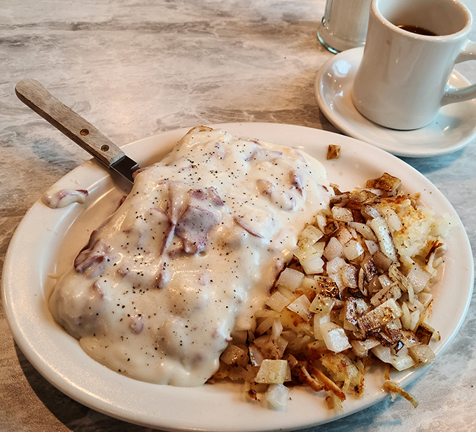 Behold the star attraction: cream chipped beef that blankets the toast like a warm hug, with crispy home fries standing by for the perfect bite combination. 
