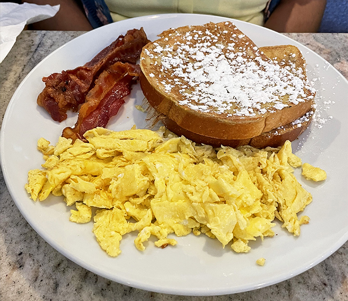 Scrambled eggs so fluffy they might float away if not anchored by that glorious French toast. Powdered sugar: nature's edible confetti.