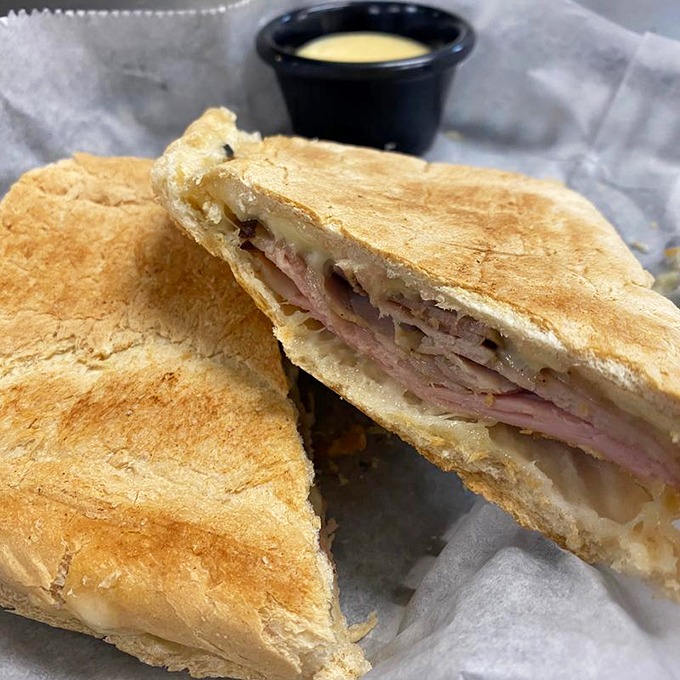 Behold the star of our show &ndash; a Cuban sandwich pressed to golden perfection, with layers that harmonize like a well-rehearsed doo-wop group.