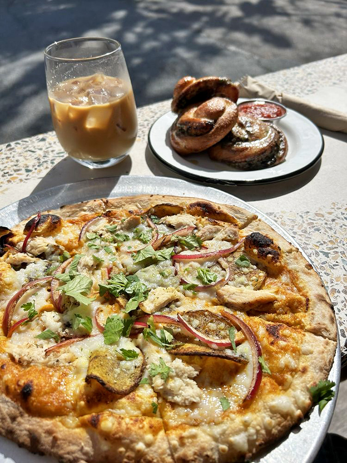 Behold the holy trinity: curry pizza that defies convention, garlic knots, and creamy oat milk latte bliss.