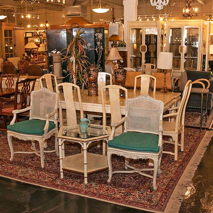 Elegant dining chairs with cane backs and teal cushions gather around a table, patiently waiting for their next dinner party to host.