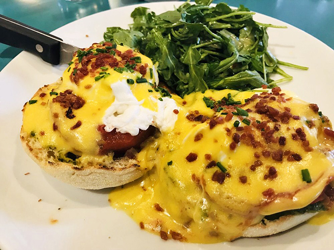 Benedict done right – hollandaise so yellow it could moonlight as sunshine, with crispy bacon bits playing the perfect supporting role.