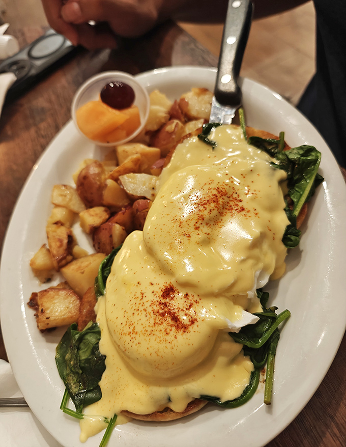 Eggs Benedict that would make the Pope jealous. Hollandaise cascades like a golden waterfall over perfectly poached eggs and fresh spinach.