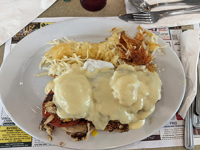 Behold, the star attraction! Eggs Benedict bathed in silky hollandaise that cascades like a buttery waterfall over perfectly poached eggs. Home fries never had better company.