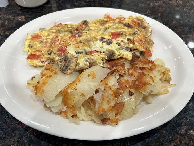 Behold the Farmer's Omelet in its golden glory! Those crispy home fries aren't just a side dish &ndash; they're the supporting actors deserving their own Oscar.