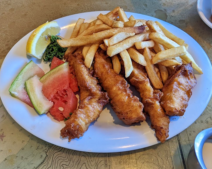 Golden-battered fish and chips that shatter at first bite, served with a side of summer fruit that somehow makes you feel virtuous about the indulgence.
