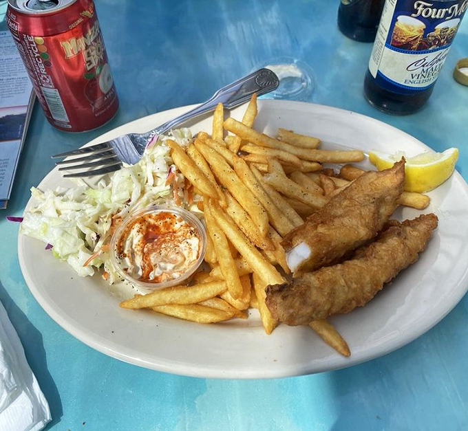 Golden-battered fish that shatters with each bite, fries that could make a Frenchman weep, and coleslaw that actually deserves its place on the plate.