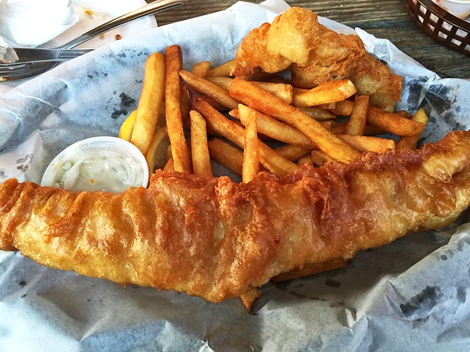 Golden, crispy batter hugging flaky white fish like it's saying goodbye at the airport. These fish and chips don't need a passport to transport you.