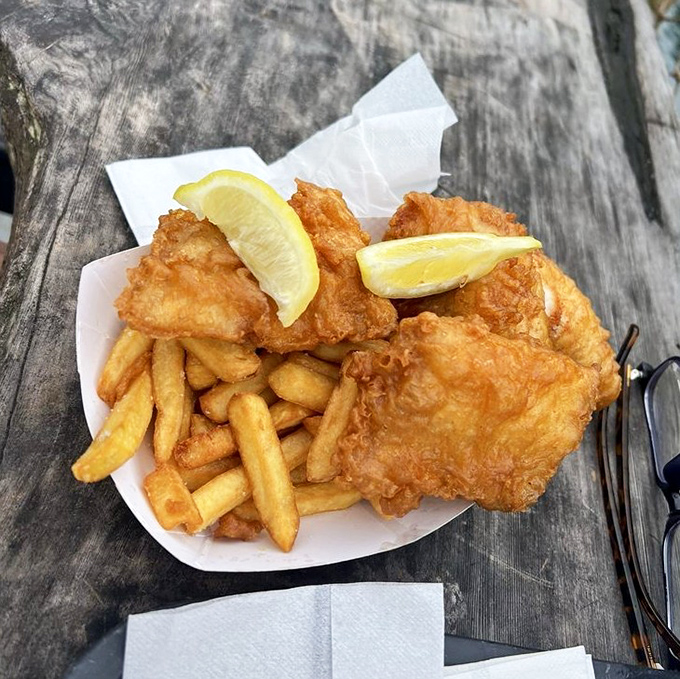 Golden-battered perfection that makes you understand why people drive hours for fish and chips. The lemon wedges aren't garnish&mdash;they're essential supporting actors.