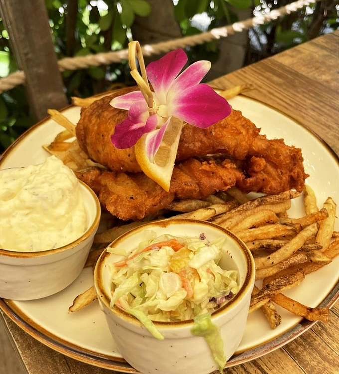 This isn't just fish and chips&mdash;it's edible sunshine with a crispy golden crust, served with a tropical flower that's saying "you're on vacation now."