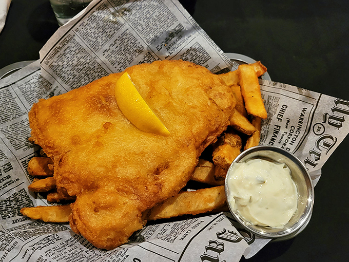 Fish and chips perfection on newspaper &ndash; as God intended. That golden batter shatters like delicate glass, revealing flaky white fish that would make Neptune himself weep.