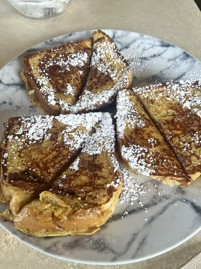 French toast that's been kissed by the griddle gods&mdash;golden, crispy edges with a custardy center, dusted with powdered sugar like fresh snow.