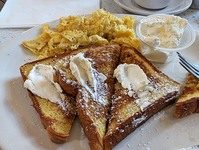 French toast nirvana achieved! Golden perfection topped with powdered sugar and cream&mdash;breakfast that's worth setting your alarm for.
