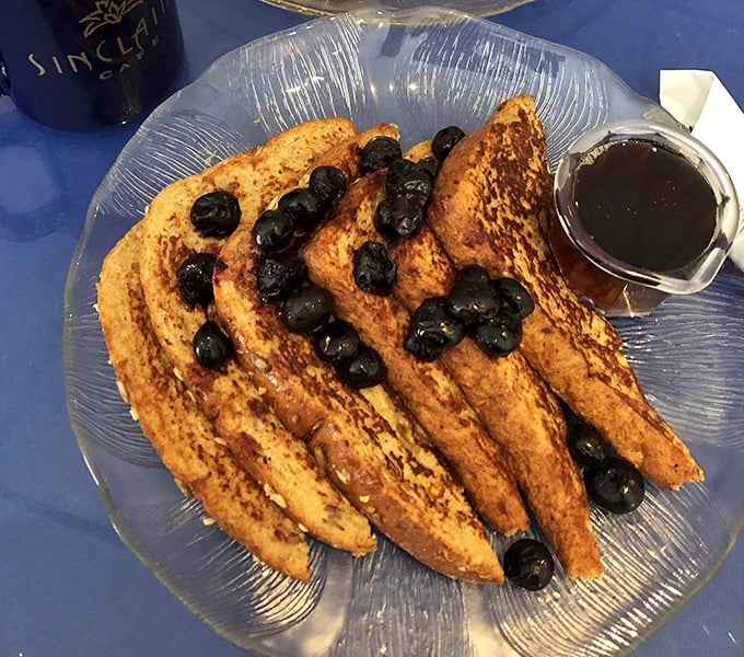 Golden-brown French toast that's achieved celebrity status in my personal breakfast hall of fame, topped with blueberries that look like they're auditioning for a food magazine cover.