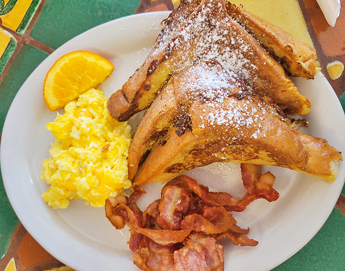 This French toast combo isn't just breakfast&mdash;it's a morning masterpiece with powdered sugar snow, golden scrambled eggs, and bacon that demands respect.