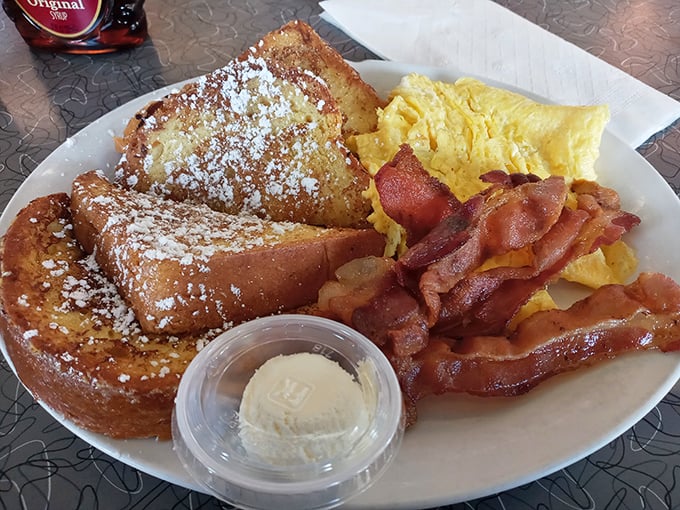 French toast that deserves its own fan club. Golden-brown perfection dusted with powdered sugar, served with eggs and bacon that know their supporting roles.