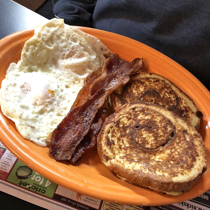 Breakfast perfection on an orange plate &ndash; golden French toast with that ideal crisp-to-custardy ratio, alongside bacon that's achieved celebrity status in pork circles.