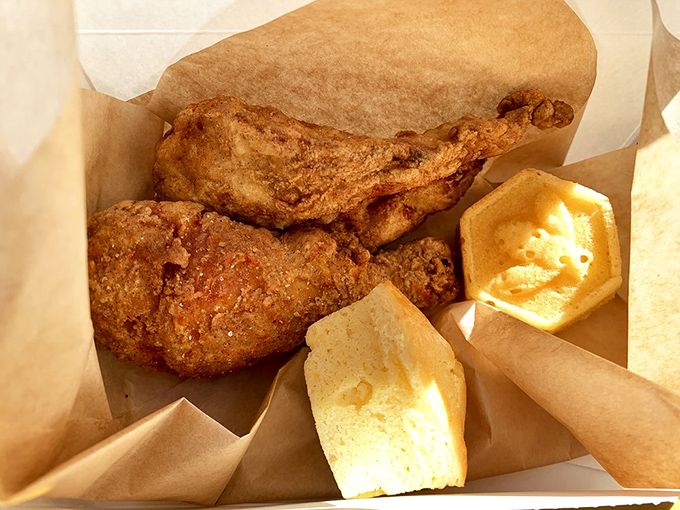 Golden-brown perfection meets honey butter in its natural habitat. This isn't just chicken; it's edible therapy with a side of corn muffins.