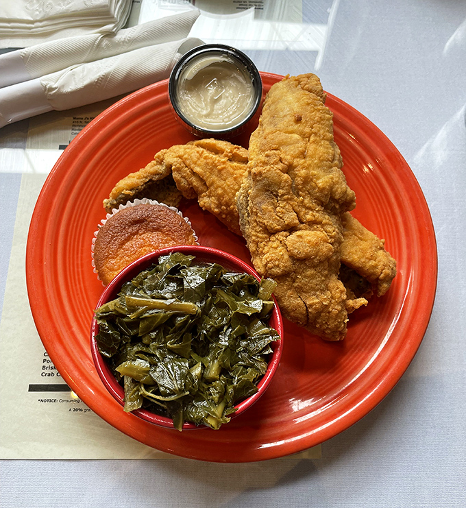 Golden-fried catfish that crackles with each bite, alongside collard greens that whisper stories of slow-simmered perfection. A plate of Southern poetry.